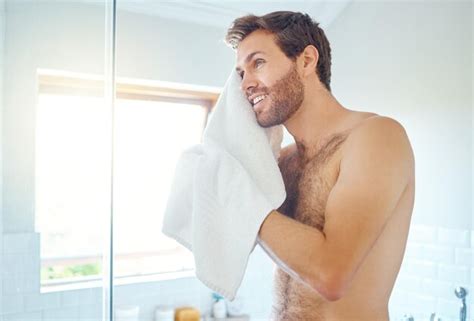 Premium Photo | Man cleaning face and towel in bathroom with smile self ...
