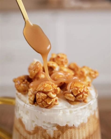 a spoon drizzling caramel on top of a dessert in a mug