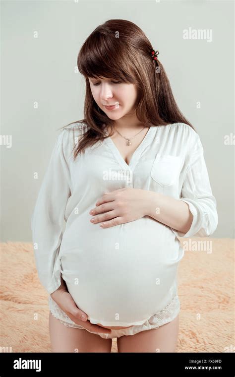 Young pregnant woman caressing her belly Stock Photo - Alamy