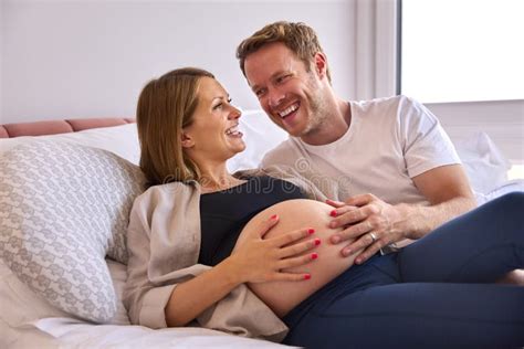 Loving Couple at Home Lying on Bed with Man Touching Pregnant Woman S Stomach Stock Photo ...