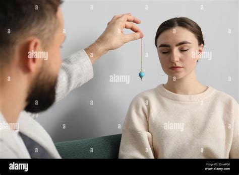 Psychologist using pendulum while working with patient during hypnosis ...