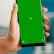 Hands of freelencer holding vertical mock up green screen chroma key ...