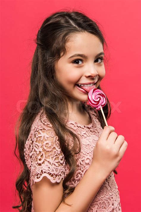 child licking colored lollipop | Stock image | Colourbox