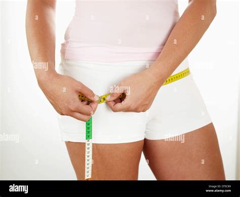 Mid adult woman measuring her waist, close up Stock Photo - Alamy