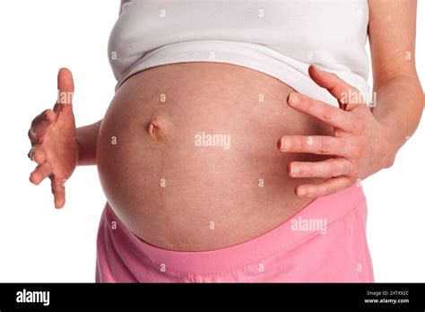 Showing the size of a large pregnant belly with female hands close up Stock Photo - Alamy