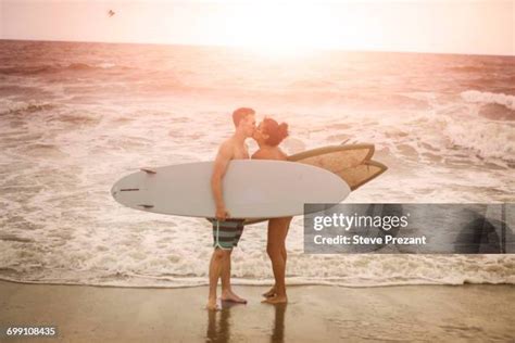 Young Couple Kissing In The Surf Photos and Premium High Res Pictures ...