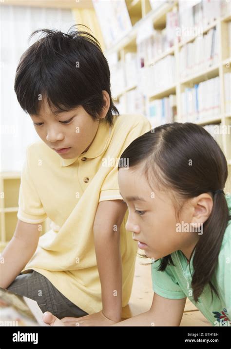 Elementary school students reading a book Stock Photo - Alamy
