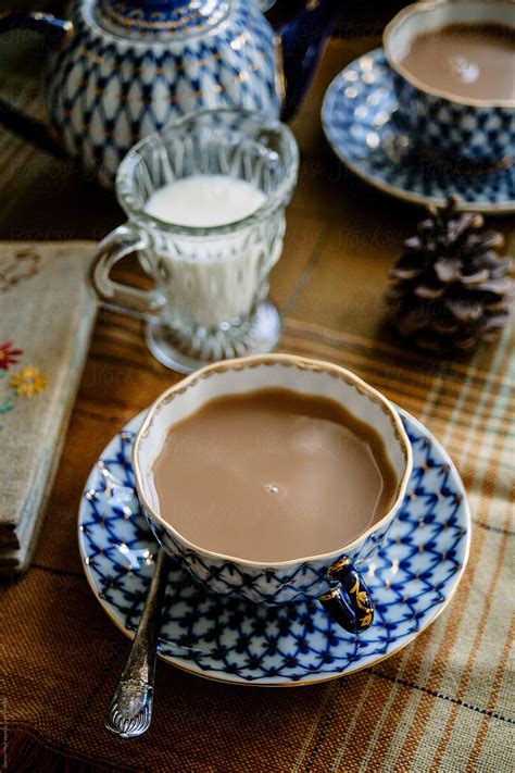 Cup of milky tea on table. by Darren Muir - Stocksy United