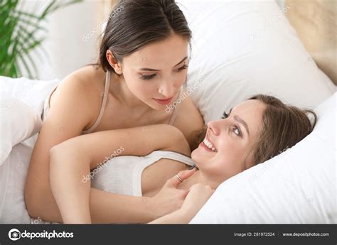 Happy lesbian couple lying in bed — Stock Photo © serezniy #281972524