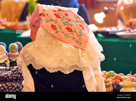 A Sorb in traditional costume sits behing decorated eggs at the 16th ...