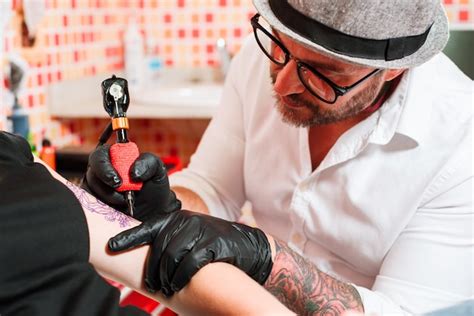 Premium Photo | Professional tattooist makes tattoo