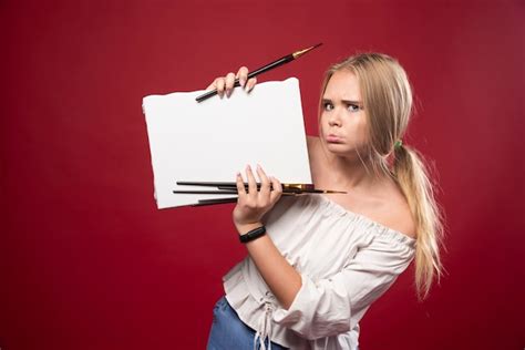 Free Photo | Blonde art master working on canvas with a paint brush and ...