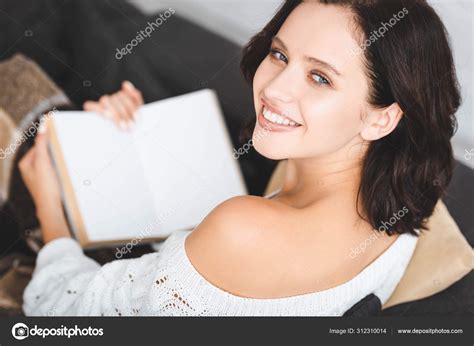 Красивая Улыбающаяся Девушка Читает Книгу Диване Дома стоковое фото ...