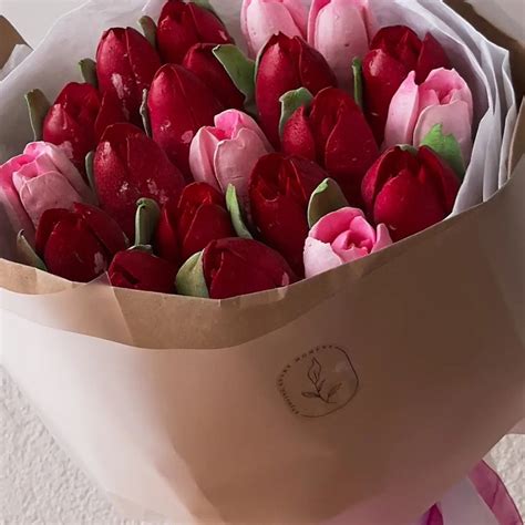 a bouquet of red and pink tulips in a paper bag
