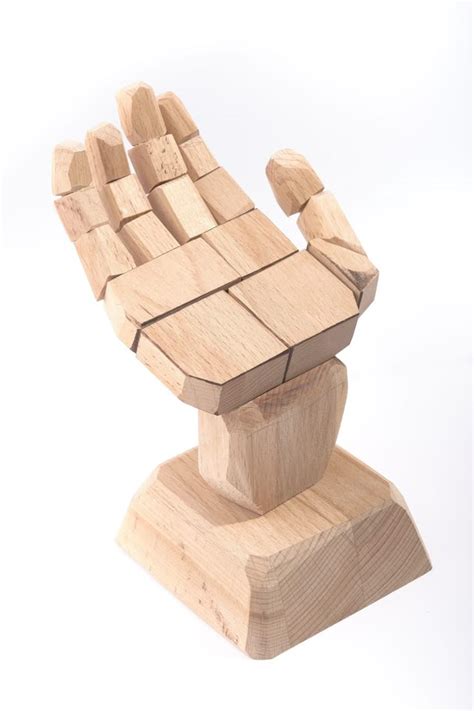 a wooden object that looks like a hand on top of a blocky wood base