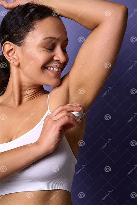 Young African Pretty Woman Applying Roll-on Deodorant Underarm Against Purple Background ...
