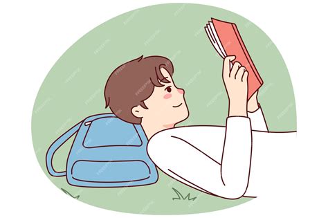 Счастливый парень лежит на траве, читает книгу, улыбается, ребенок ...