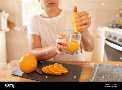 women's hands squeezing juice out of orange slices Stock Photo - Alamy