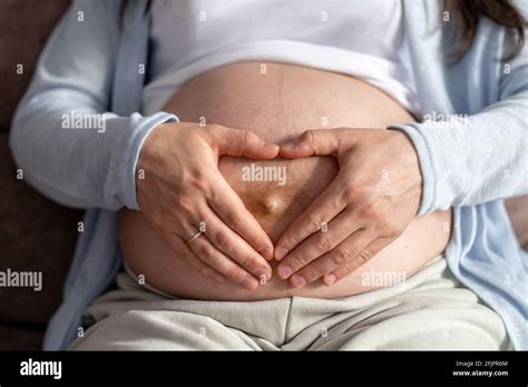 Pregnant woman resting hands on belly hi-res stock photography and images - Alamy