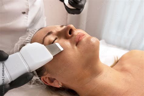 Procedure with ultrasonic skin scrubber. Woman face scrubber treatment ...